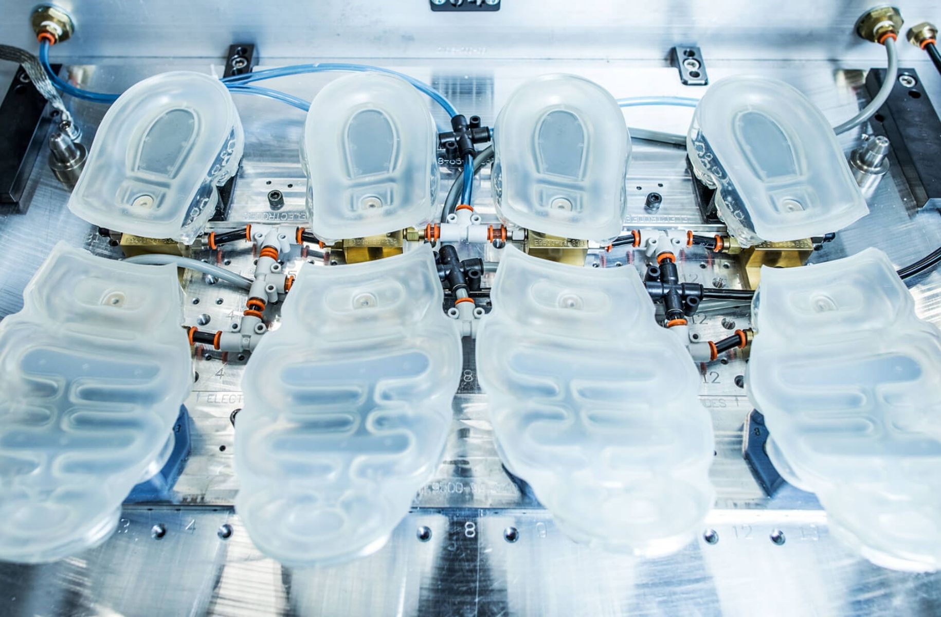 Nike air soles on a manufacturing machine with wires and tubes behind ...